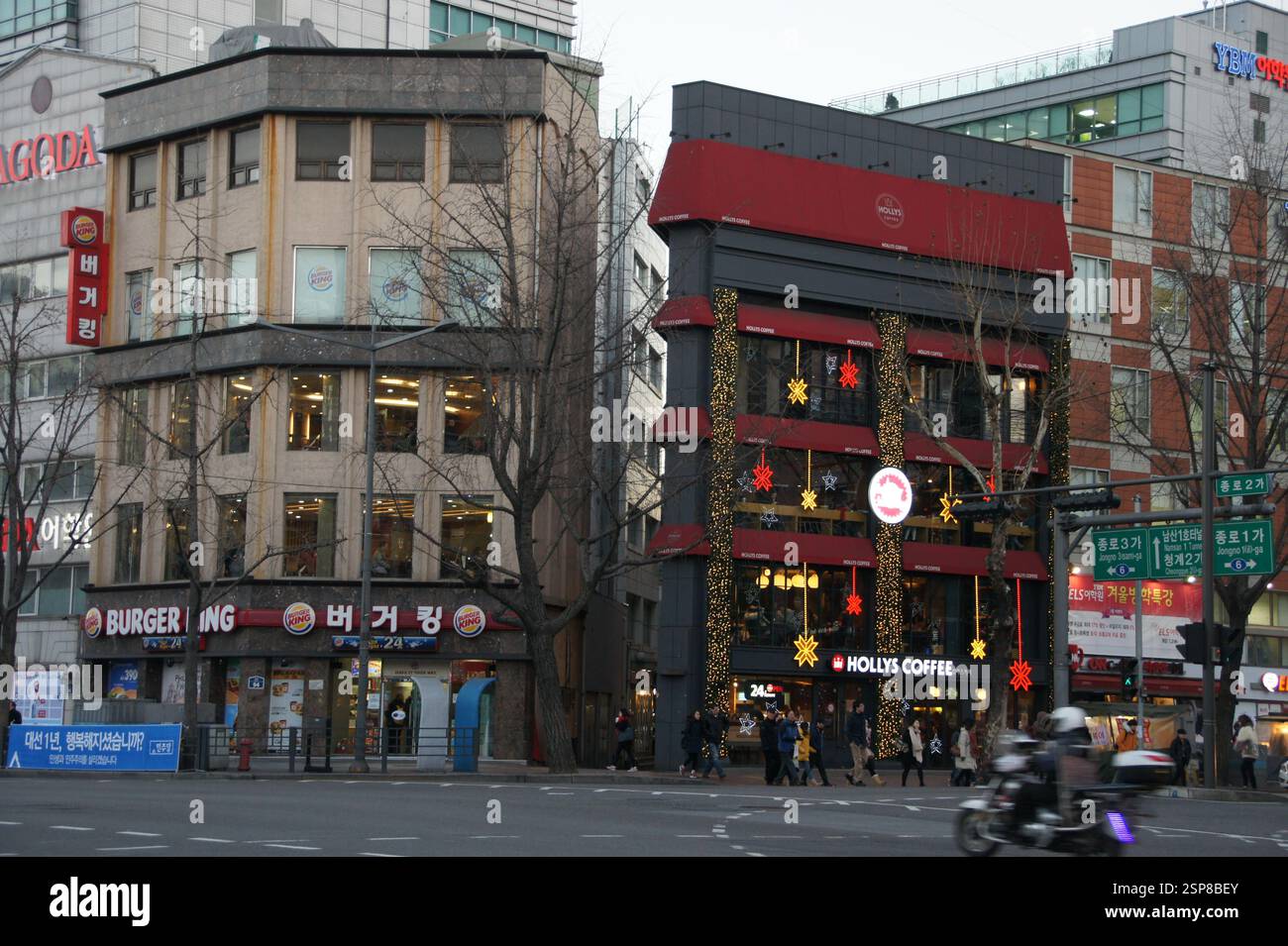Seoul, South Korea. Burger King and Hollys Coffee stores share a corner. Korean signage and ...
