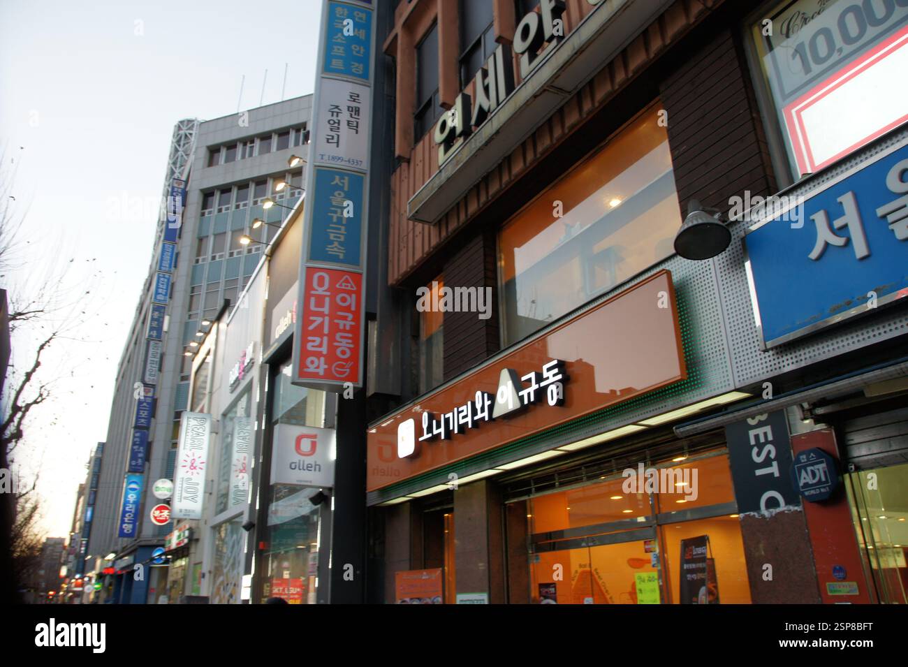 Seoul Street. Orange and blue signs with Korean writing. Windows with ...