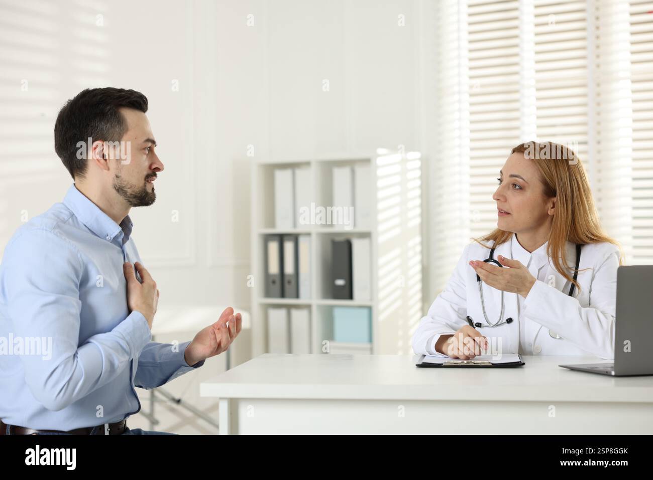 Man having consultation with cardiologist at desk in clinic Stock Photo ...