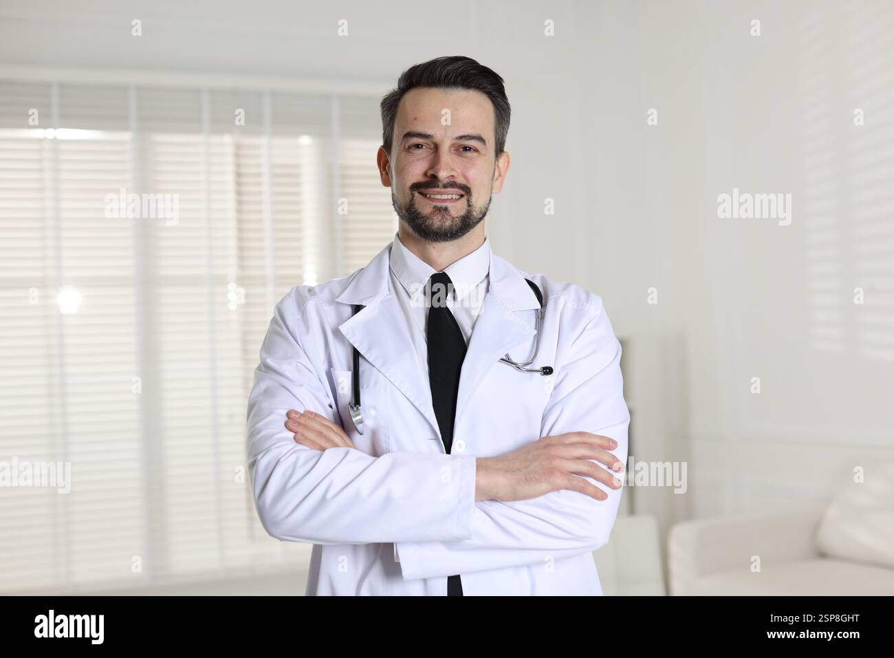 Portrait of smiling cardiologist with crossed arms in clinic Stock ...