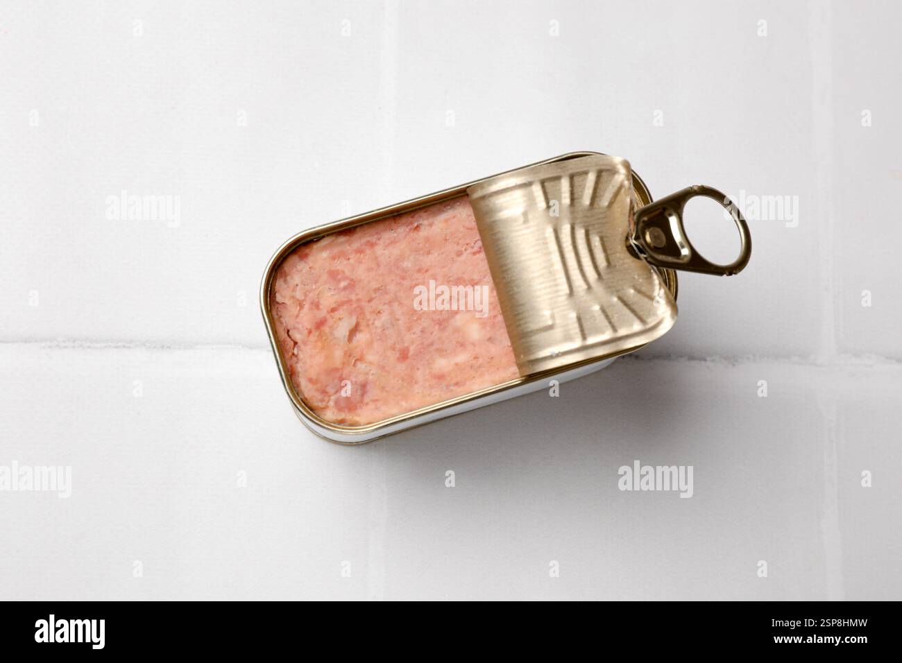 Tasty canned meat in tin can on white tiled table, top view Stock Photo ...
