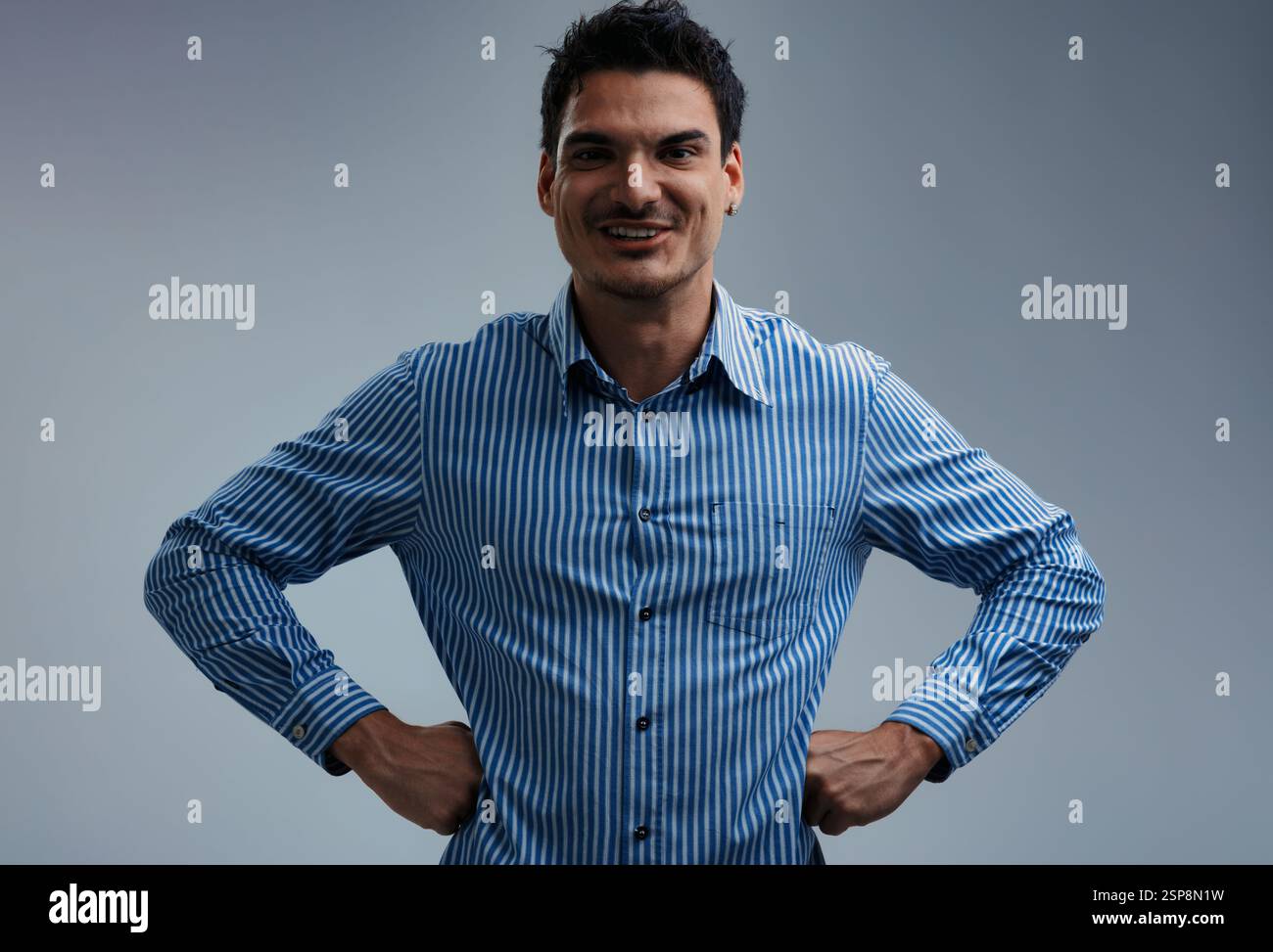 Portrait of a smiling businessman confidently standing with hands on ...