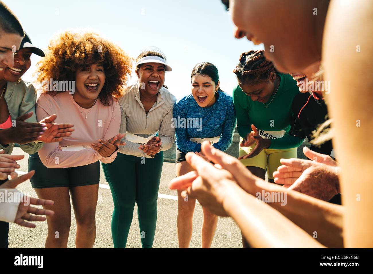 A vibrant group of diverse runners display enthusiasm and support as ...