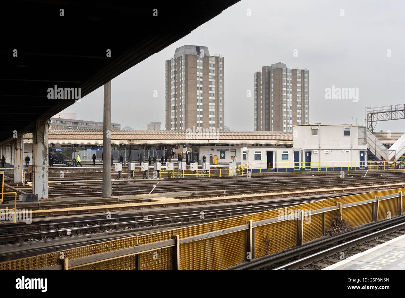 Commuters at Clapham Junction station, London, UK. Railway tracks and ...