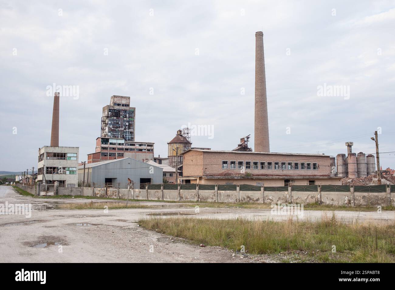 Industrial complex with multiple brick buildings, tall chimneys, and ...