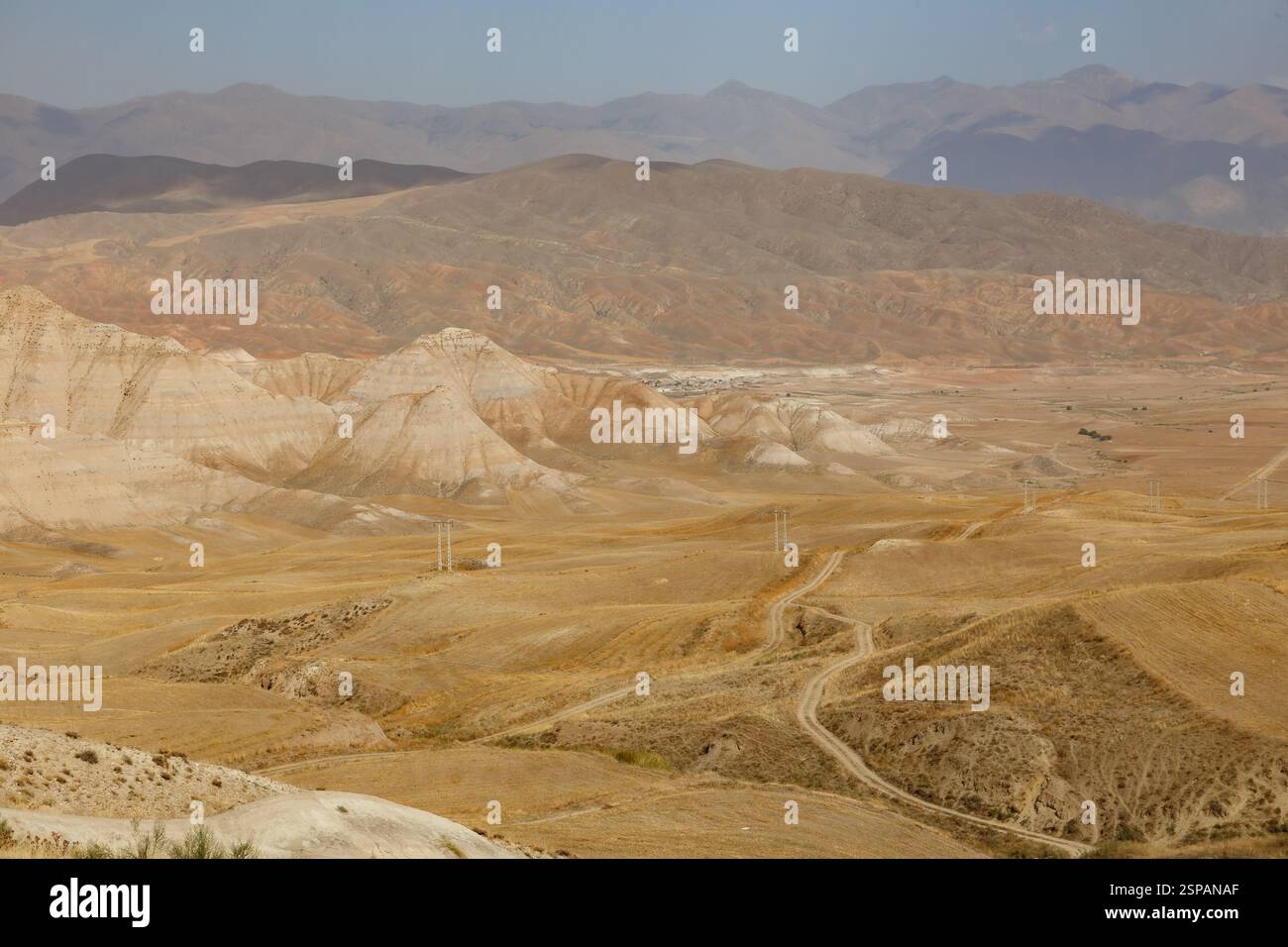 Wide view of Iran's barren terrain featuring distinct hills and distant ...