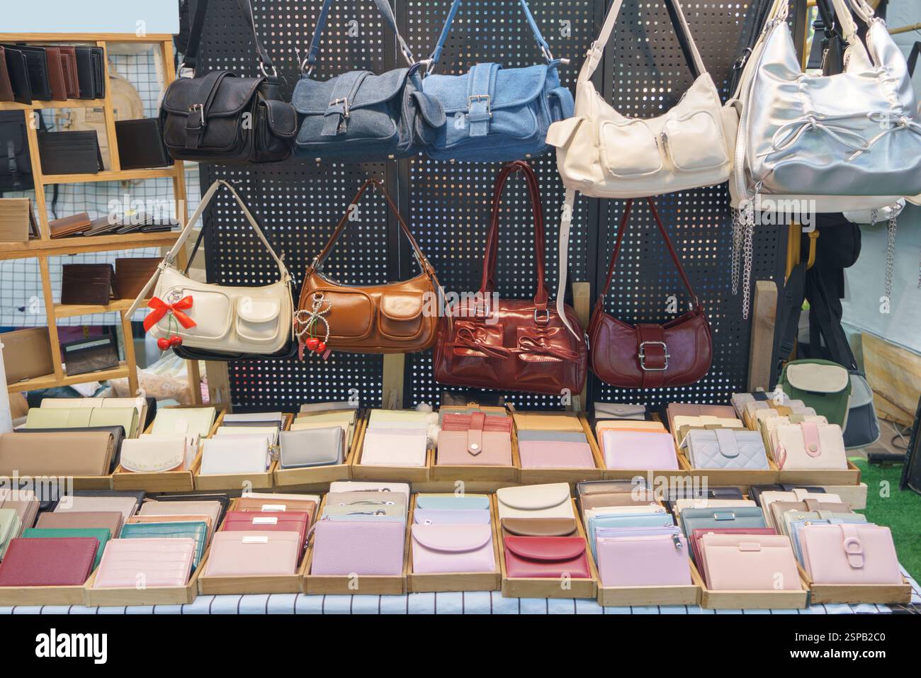 close-up shot of various handbags, purses, and wallets neatly arranged ...