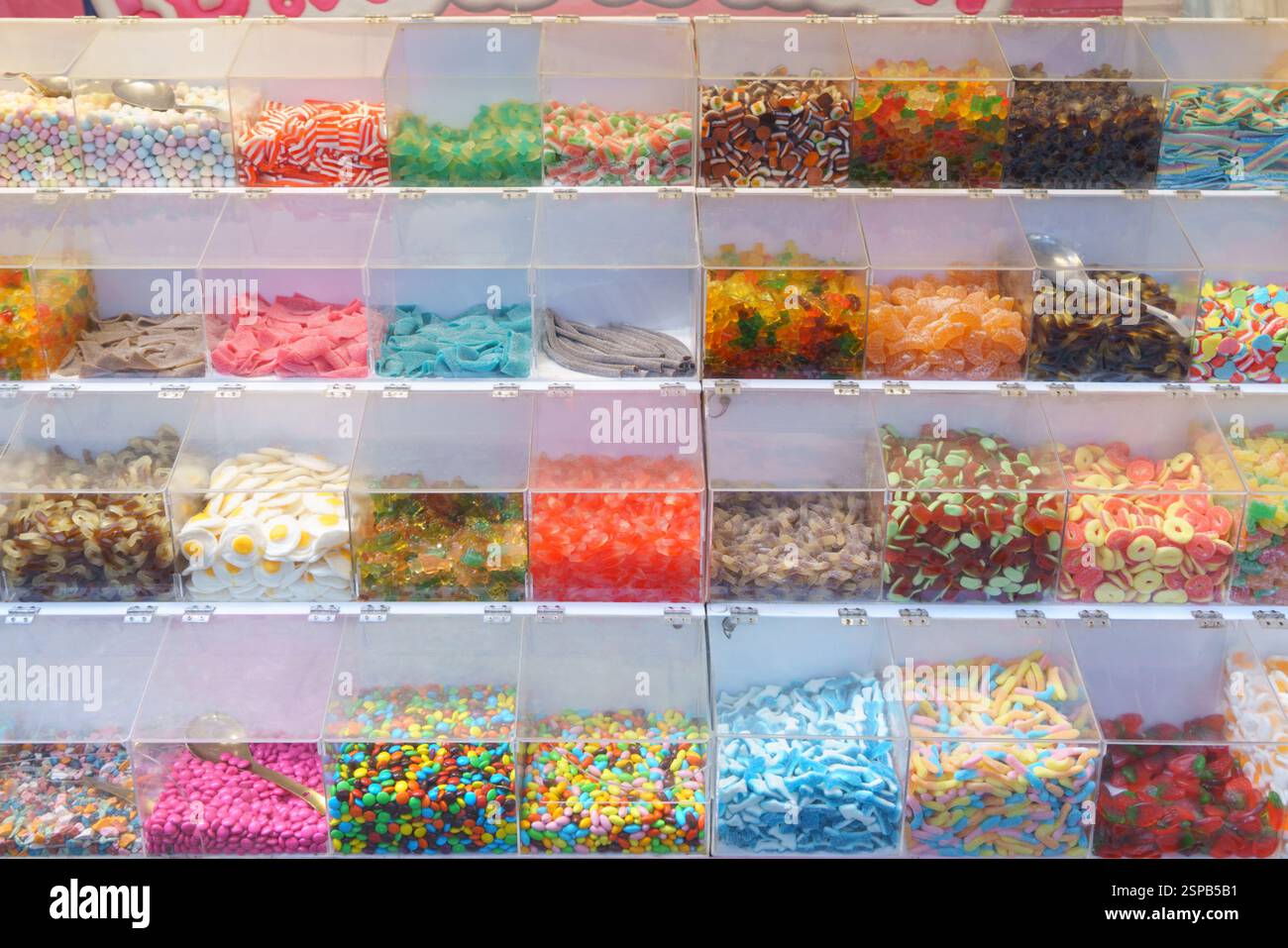 Rows of transparent bins filled with a variety of colorful candies ...