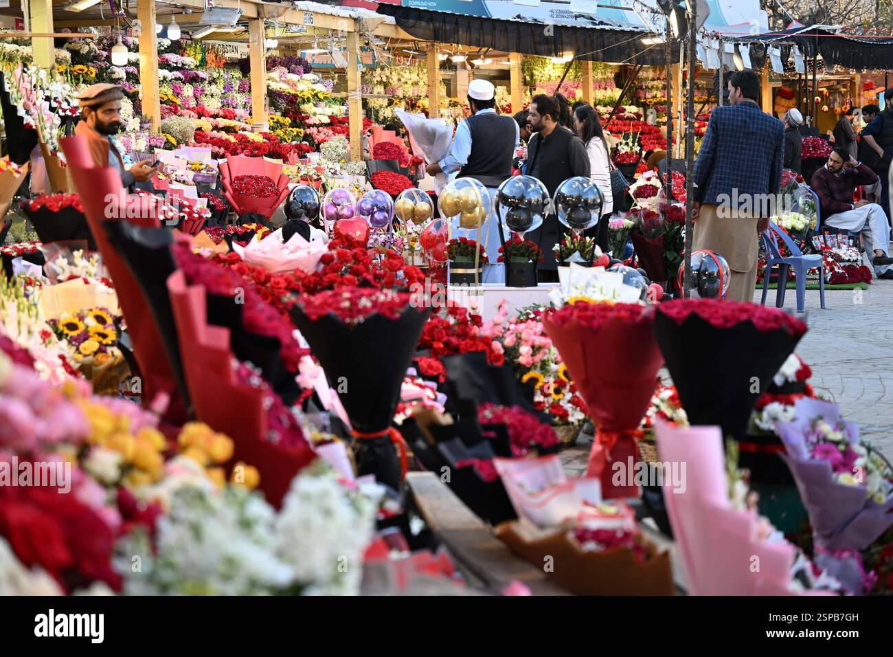 Islamabad, Pakistan. 13th Feb, 2025. People buy flowers at a flower ...
