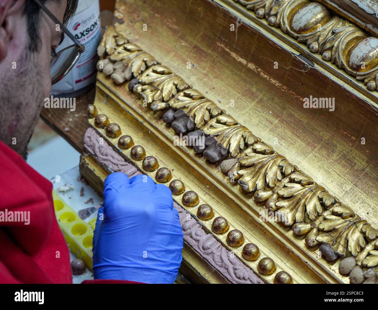 Craftsmanship, craftsman. Restoration of an antique gilded frame, hands ...