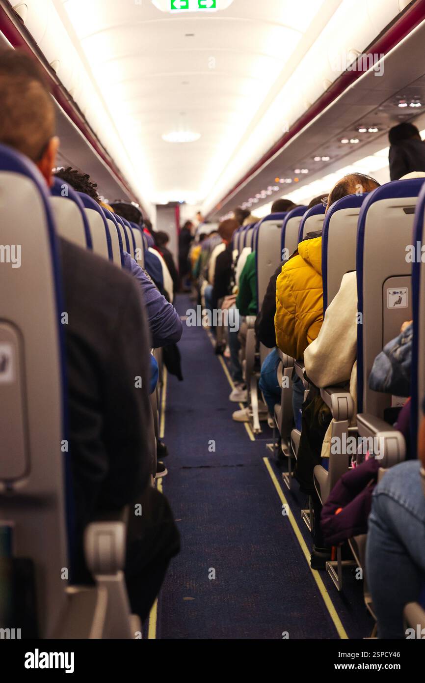 aisle with seats in a plane full of people Stock Photo - Alamy
