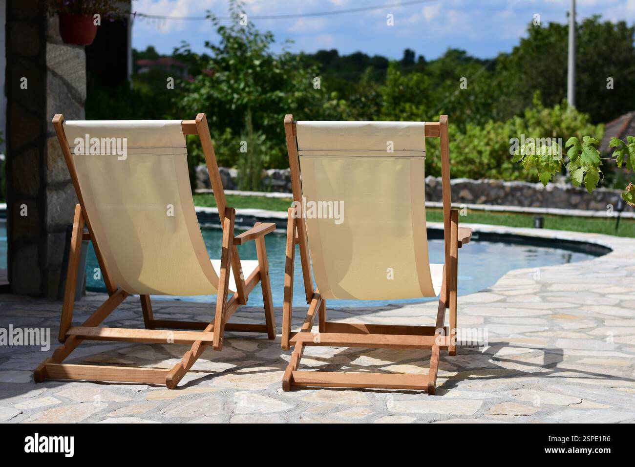 A pair of relaxing chairs for sunbathing by the pool Stock Photo - Alamy