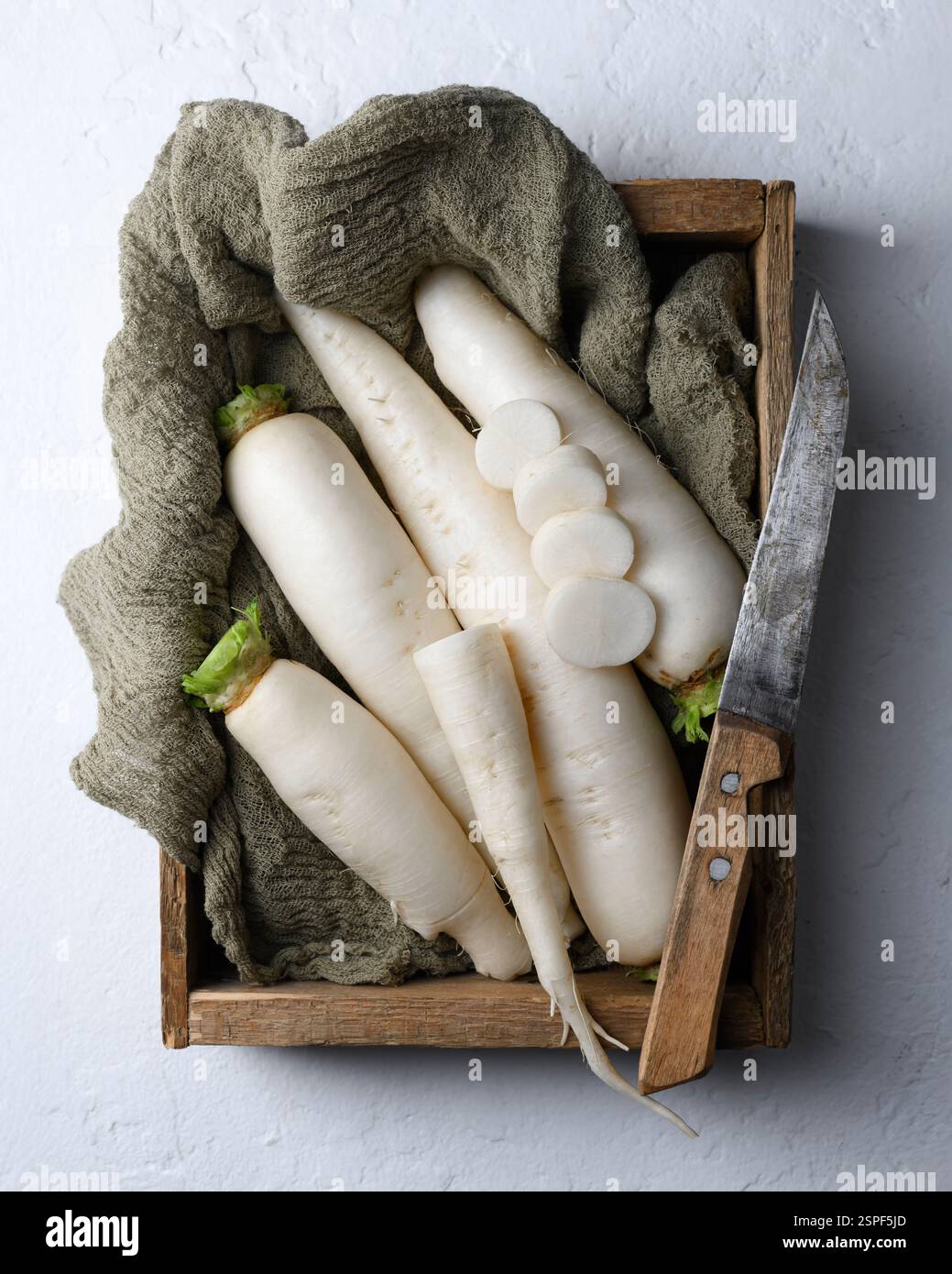 Wooden box filled with fresh white daikon radish roots on a rustic ...