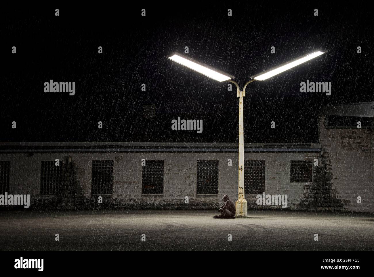 Sad tired and depressed man sitting on the ground in the rain ...