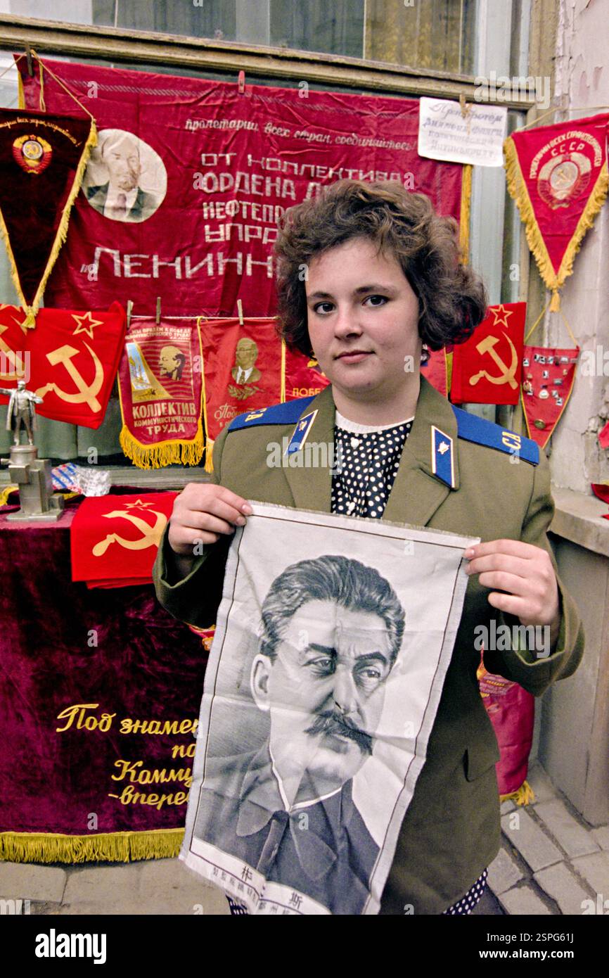 A young Russian woman holds a portrait of Soviet leader Joseph Stalin ...
