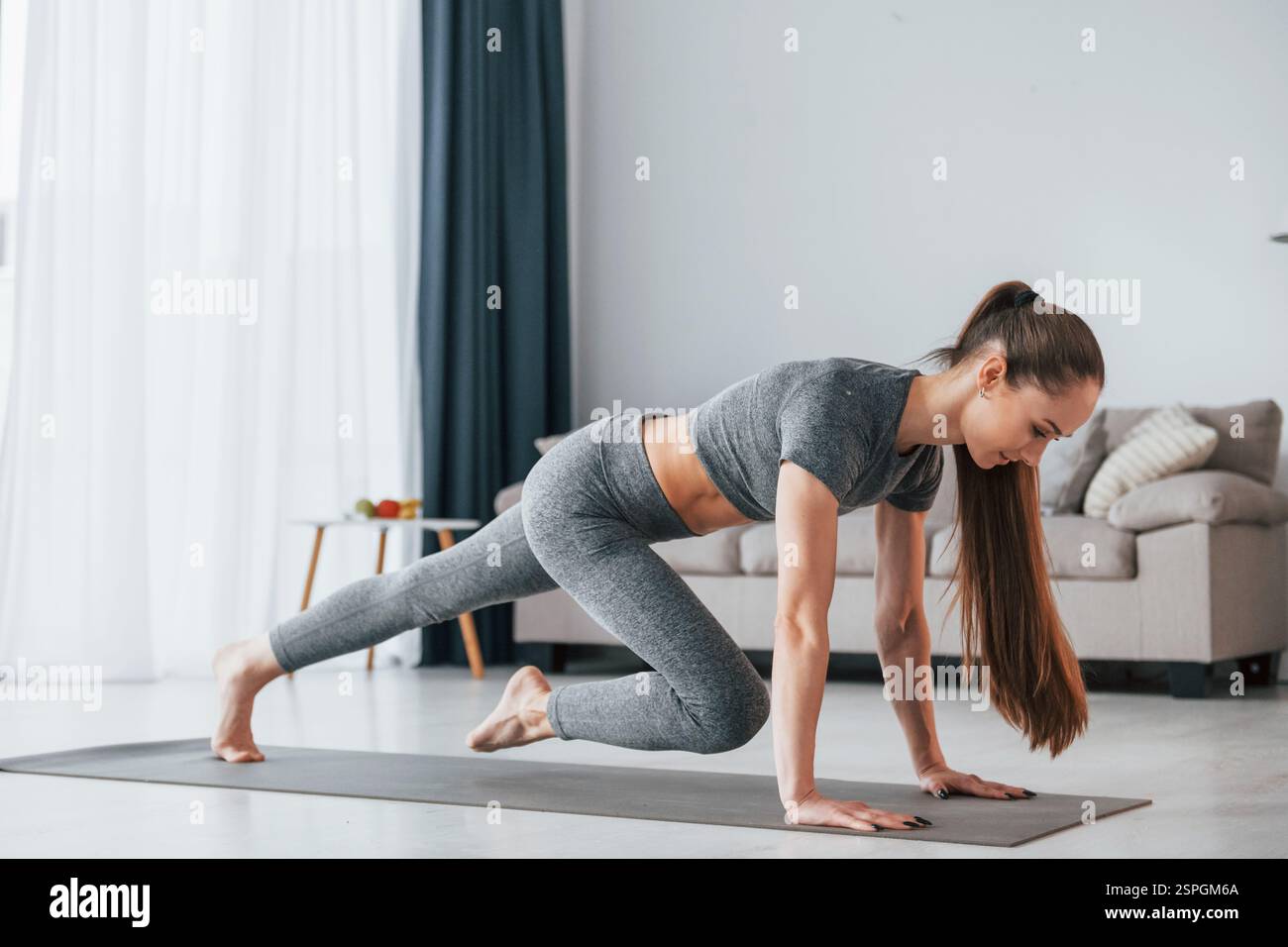 Doing plank exercise. Young woman with slim body type and in yoga ...