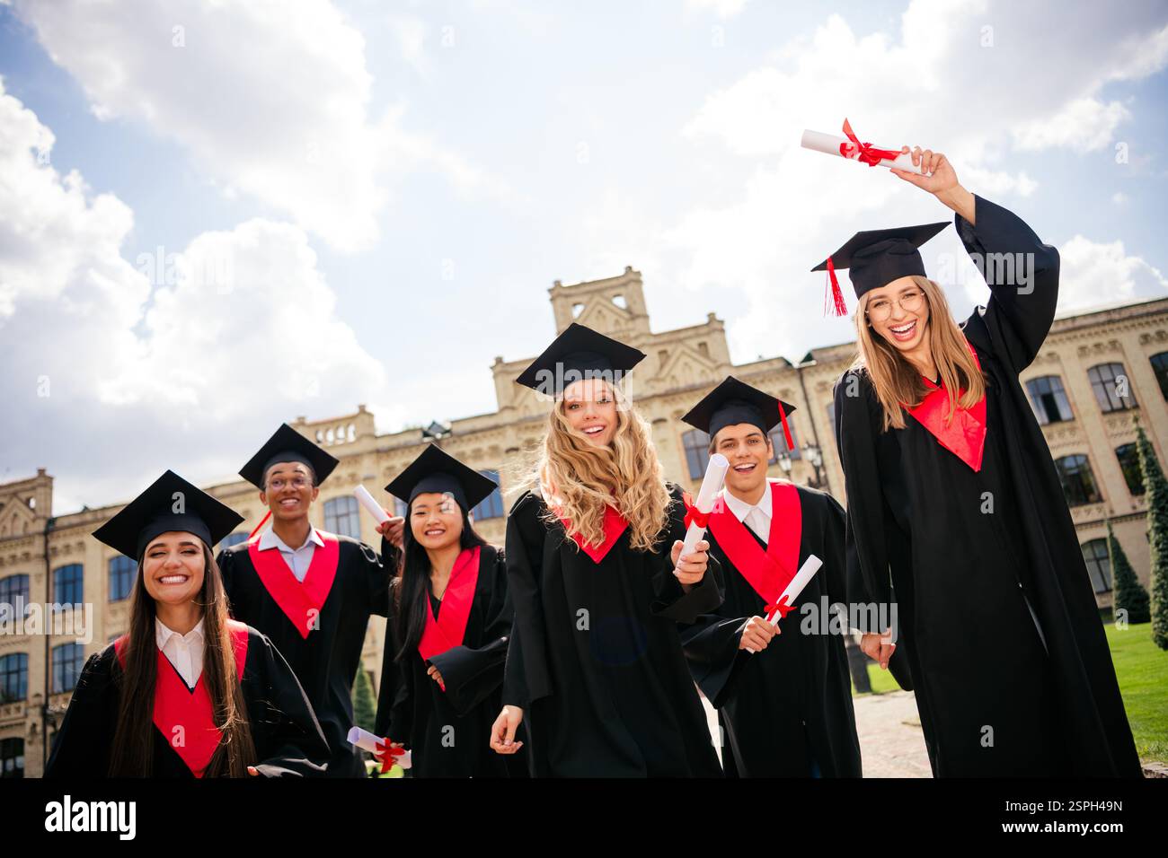 Joyous young graduates celebrate their academic achievement outdoors ...