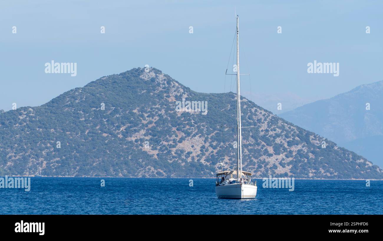 A sailboat anchored in the turquoise waters of Sarsala Bay, Dalaman ...