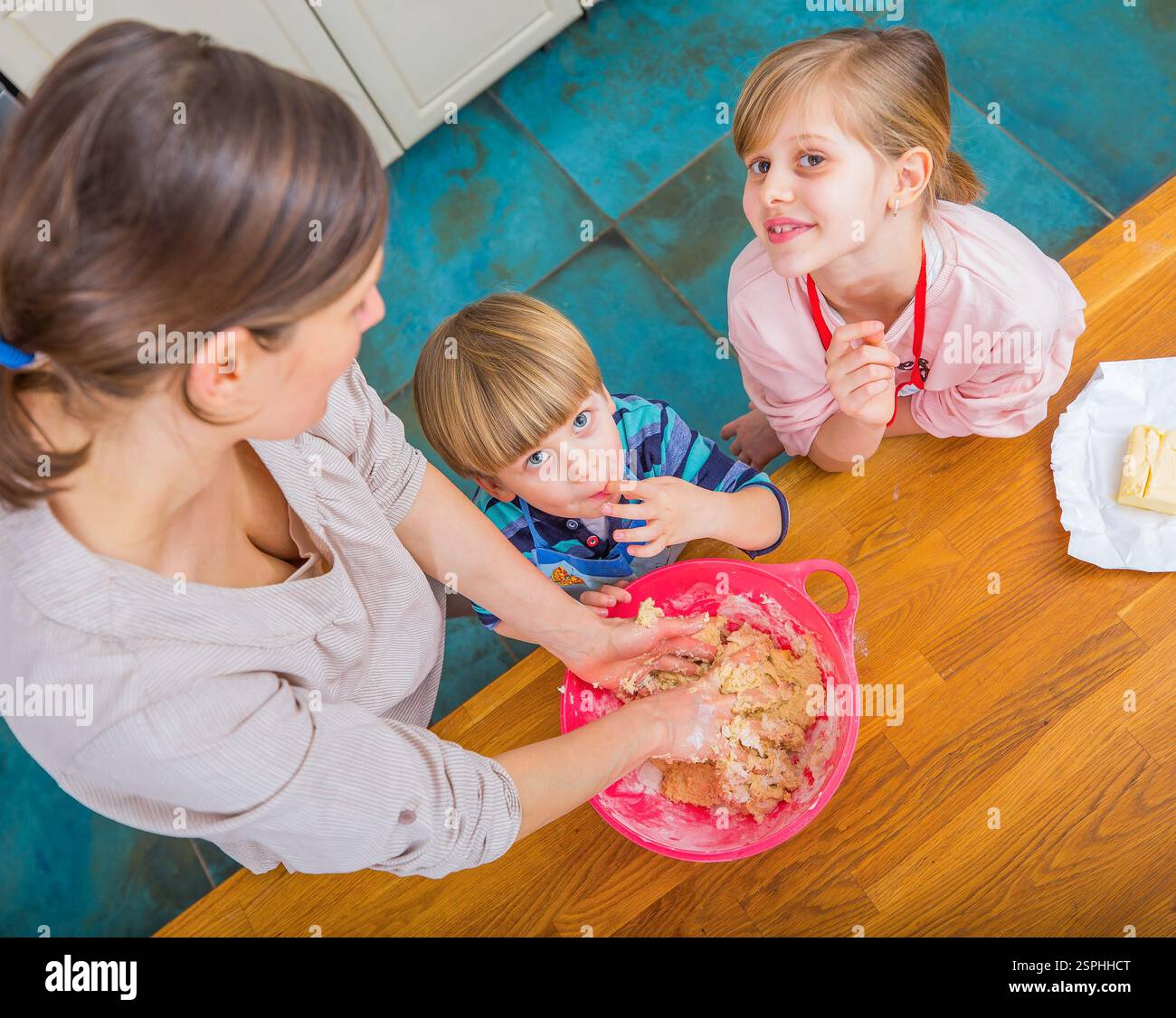 A mother and her children bonding while preparing cookie dough on a ...