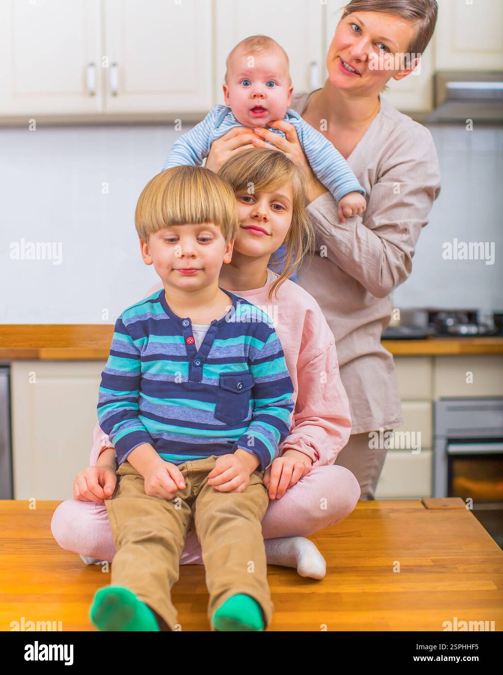 Family bonding in a cheerful moment within a warm kitchen setting ...