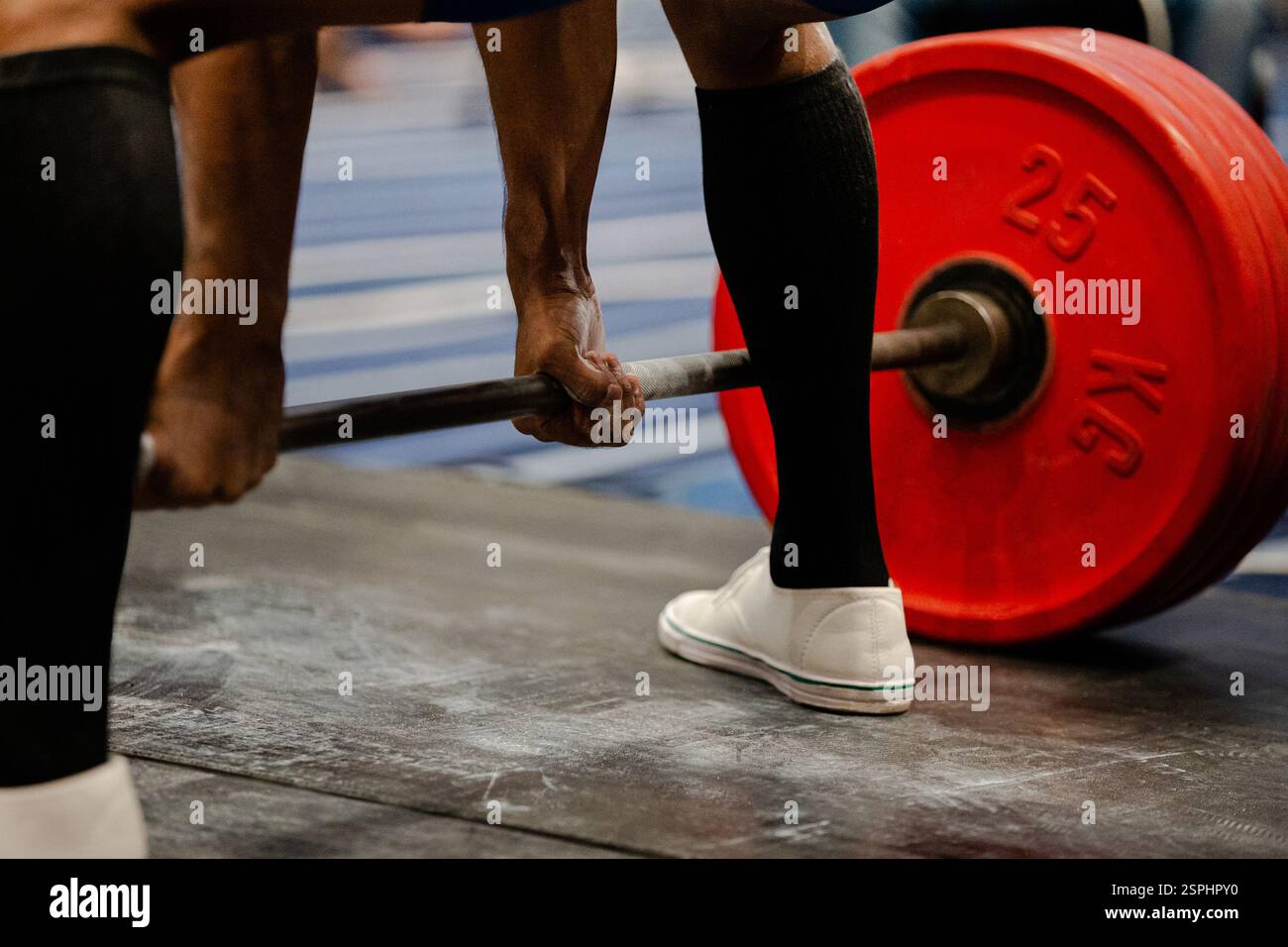 powerlifter athlete focuses on lifting heavy barbell during deadlift ...