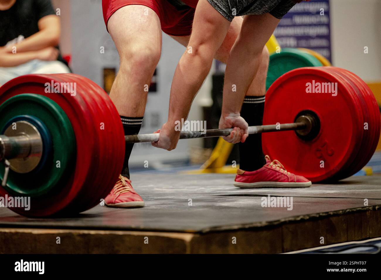 strong athlete focuses on lifting heavy barbell during deadlift ...