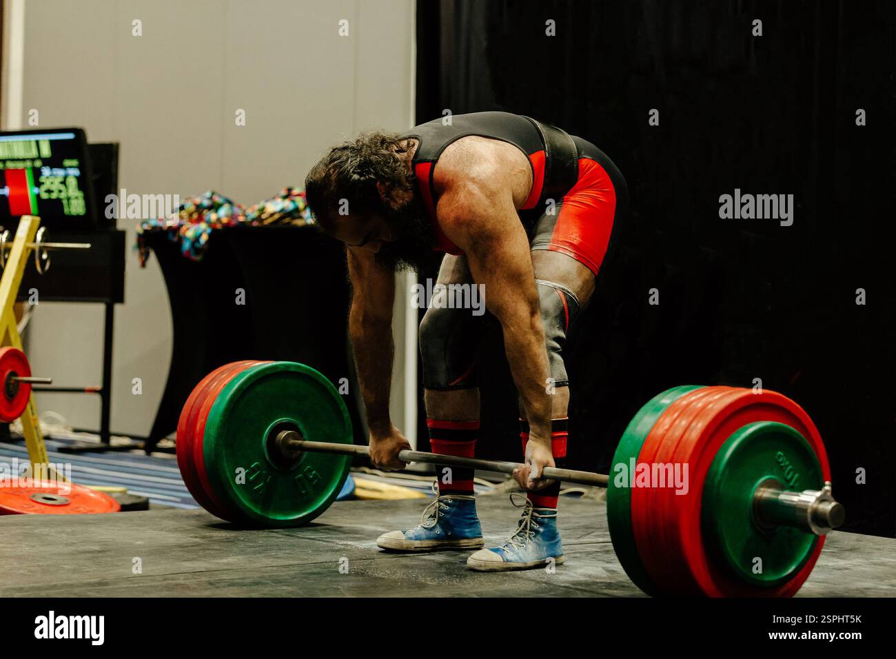 powerlifter athlete bent down barbell to perform deadlift exercise ...