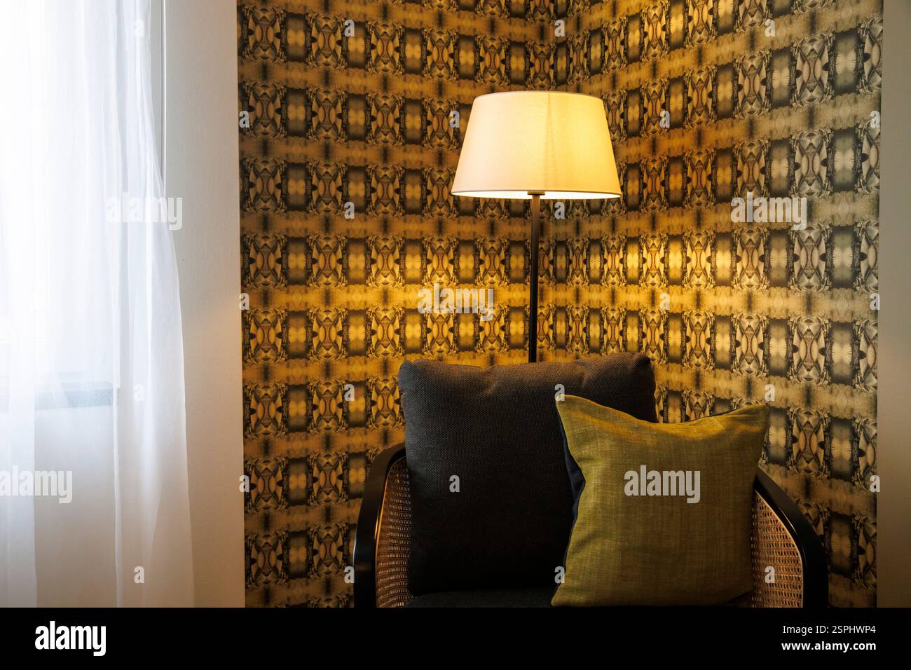striking wallpaper, floor lamp, armchair with cushions in a hotel room ...