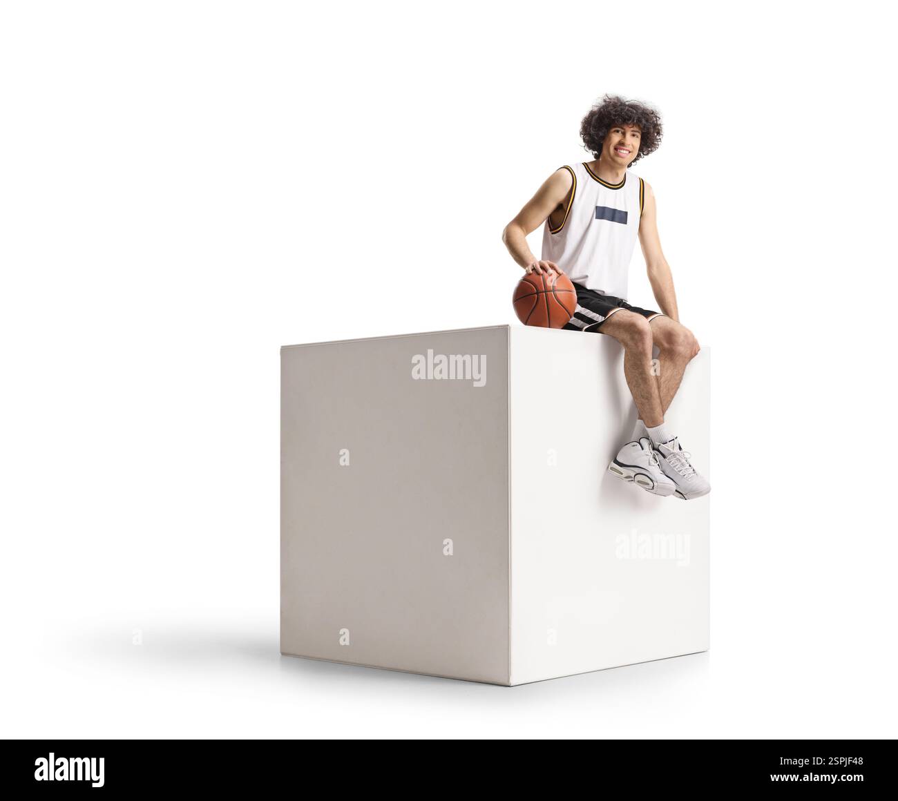 Basketball player sitting on a white cube isolated on white background ...