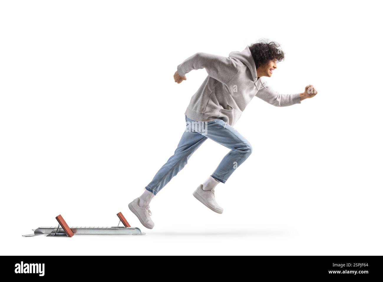 Tall young man in jeans and hoodie running from a starting block ...