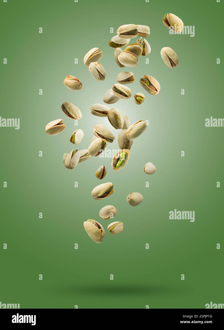 Pistachio nuts flying on green background Stock Photo - Alamy