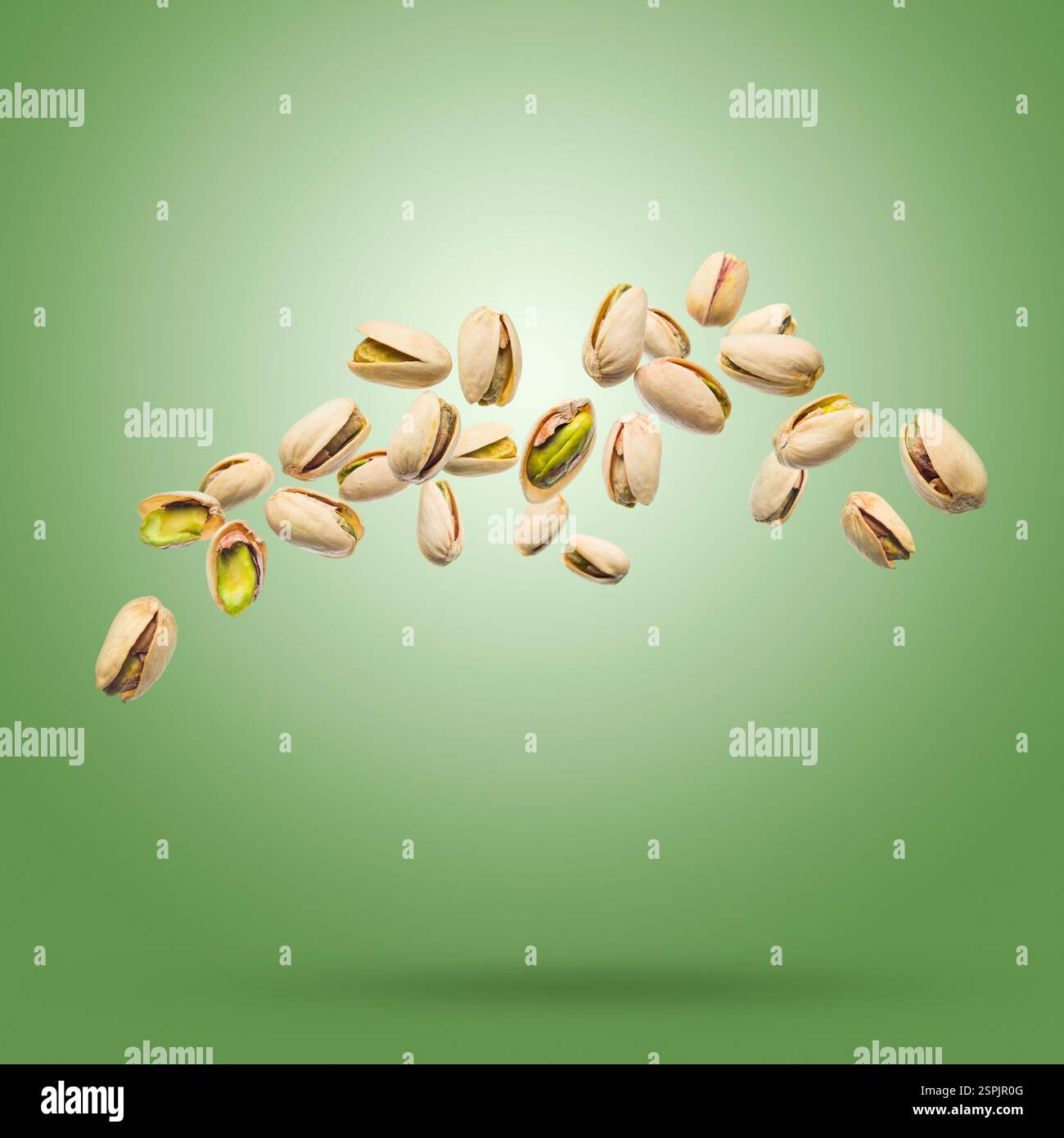 Pistachio nuts flying on green background Stock Photo - Alamy