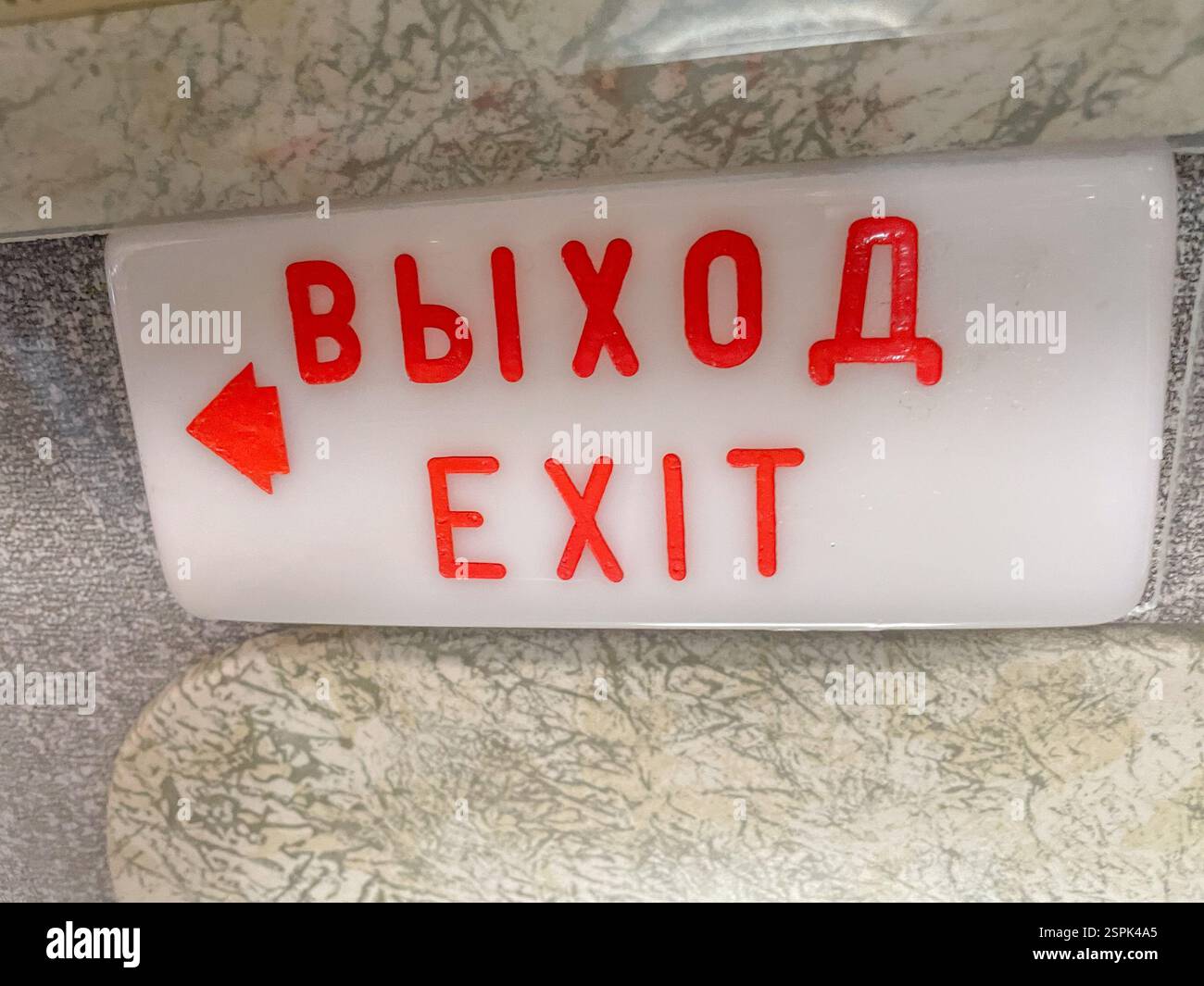 A close-up shot of a rectangular white sign with red lettering. The ...