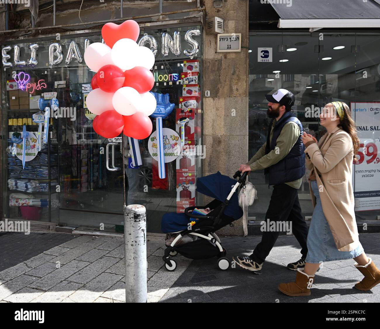 Jerusalem, Israel. 14th Feb, 2025. An Israeli passes a shop displaying ...