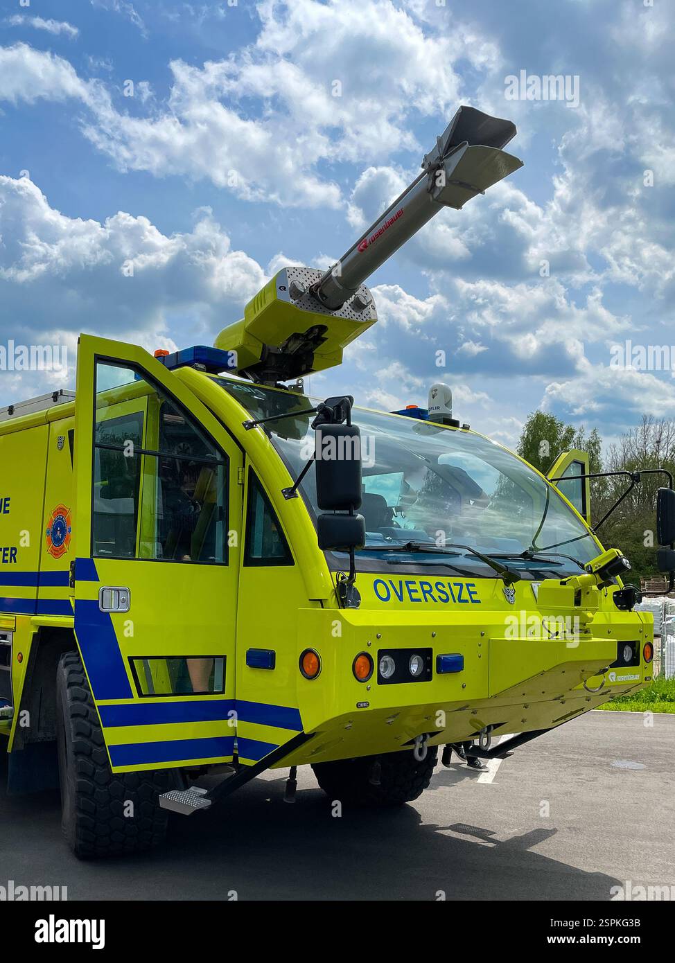 Close-up view of a lime-green fire truck with a large extending water ...
