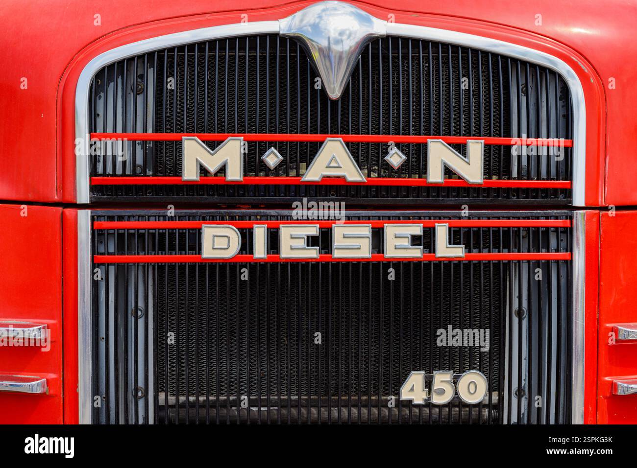 Close-up view of a red MAN Diesel 450 truck's grill. The grill features ...
