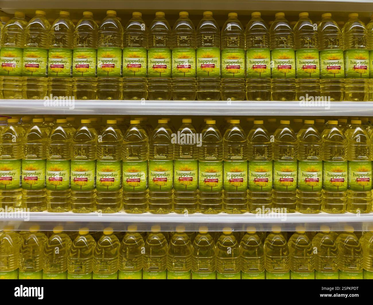 Three shelves display numerous amber-colored plastic bottles of ...