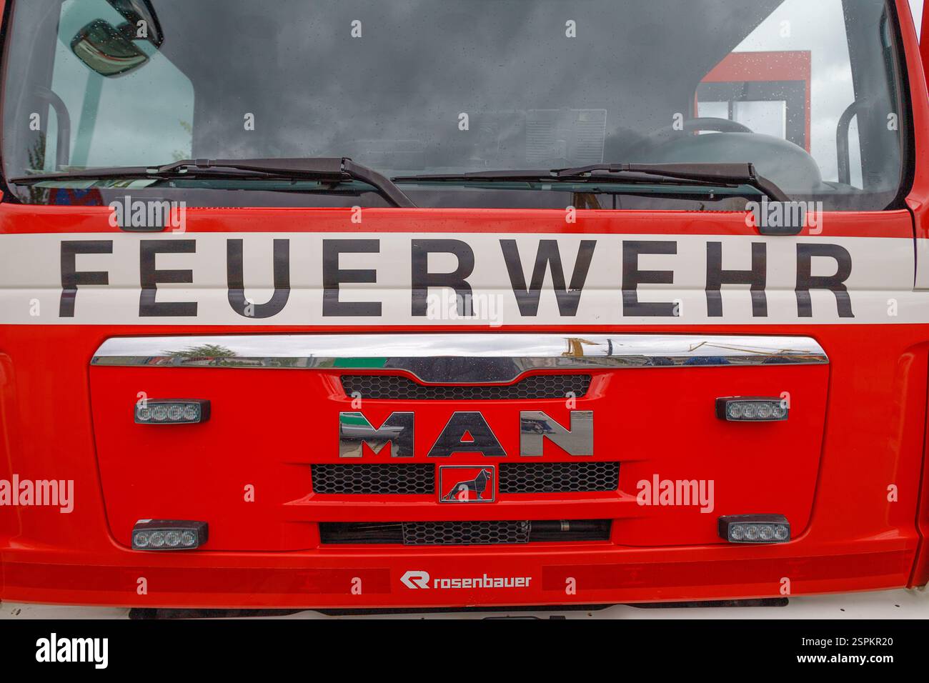 Close-up view of the front of a red firetruck. The word "FEUERWEHR ...