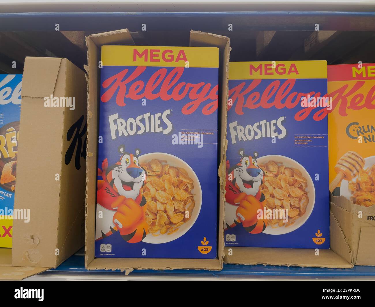 A shelf displays several boxes of Kellogg's Frosties cereal. Two prominently feature Tony the ...