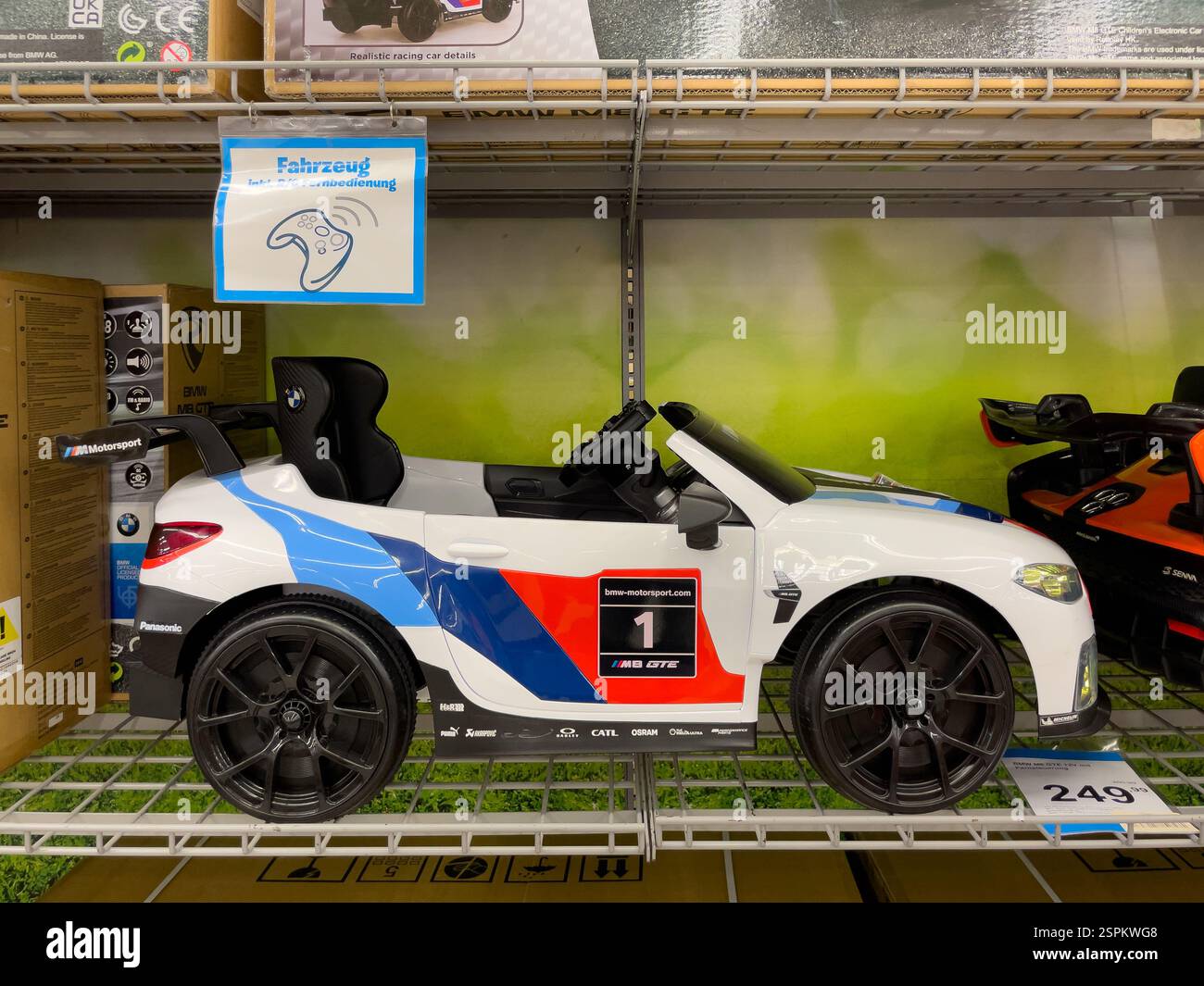 A white, blue, and red children's ride-on BMW M6 GT3 toy car sits on a ...