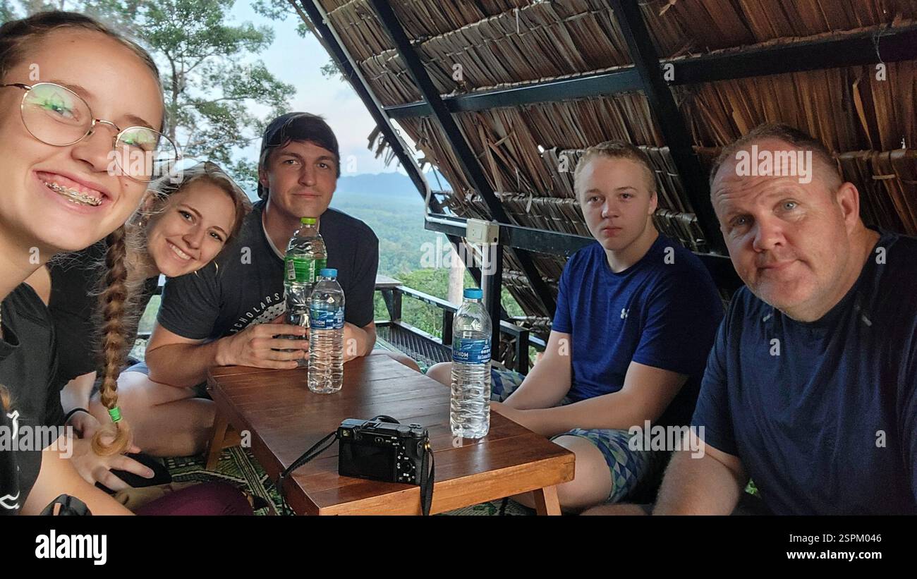 A group of friendly people are happily sitting around a table Stock ...