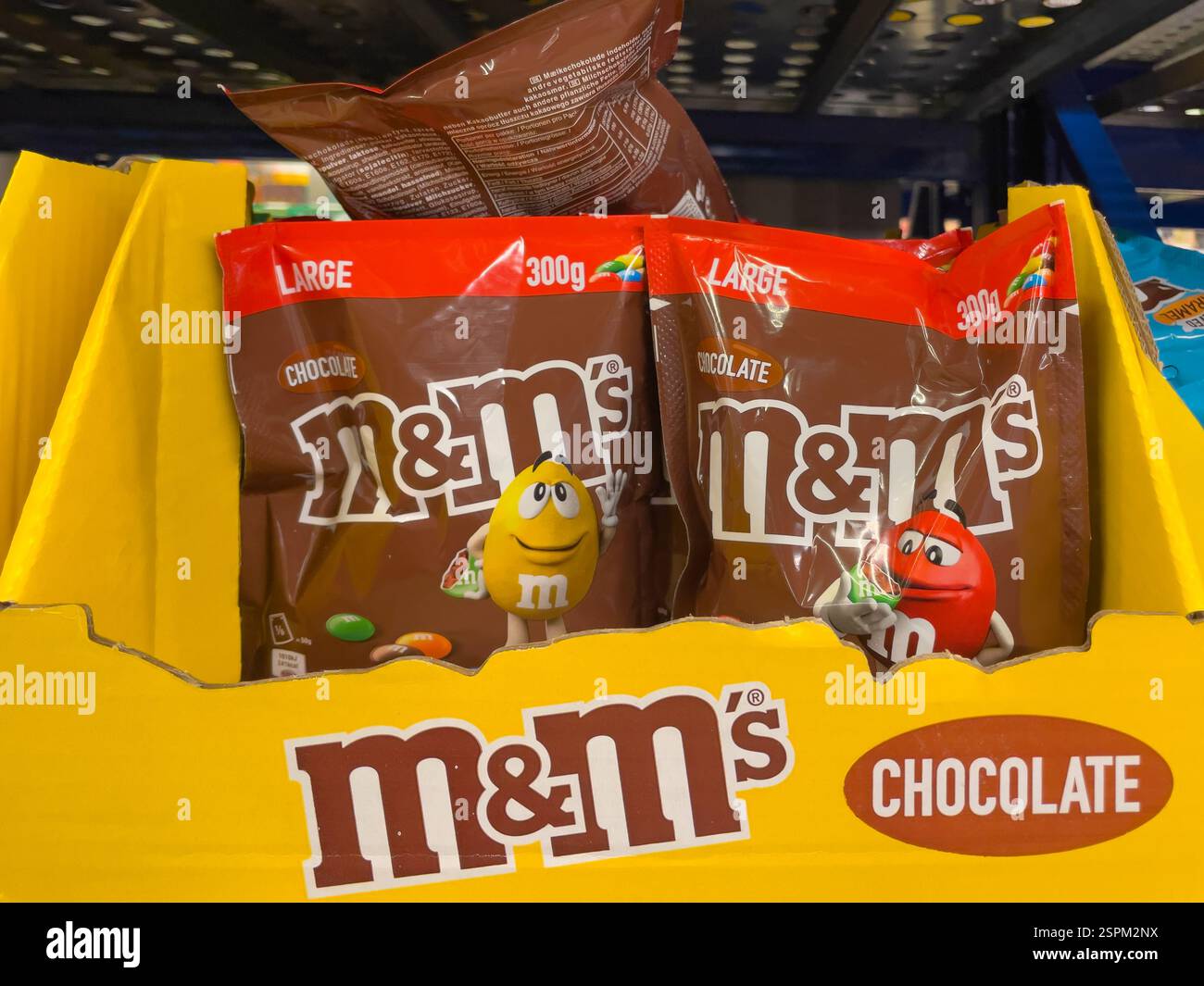 A yellow cardboard display box contains two large 300g bags of M&M's ...