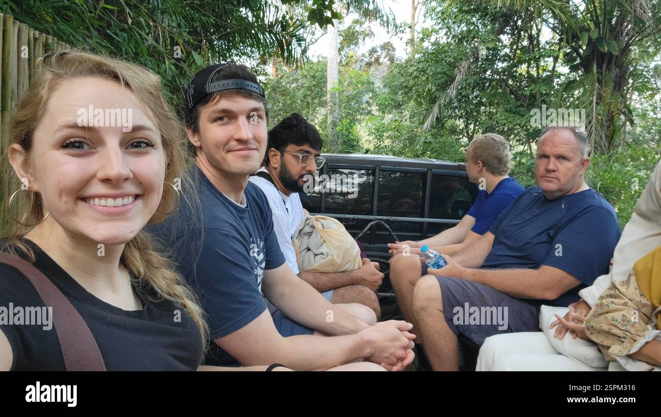 A diverse group of people are happily sitting in front of a truck Stock ...