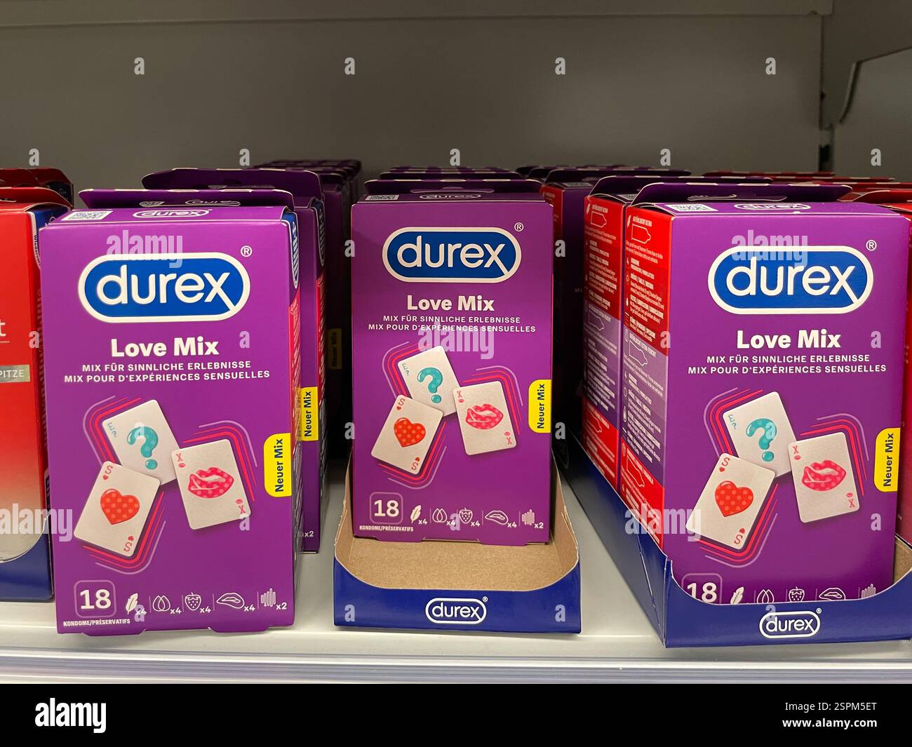A shelf displays multiple boxes of Durex Love Mix condoms. The purple boxes feature a design ...