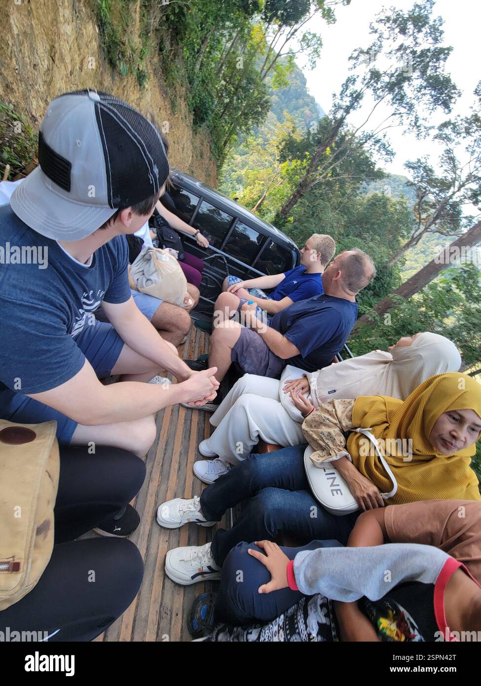 A diverse group of people are happily sitting in front of a truck Stock ...