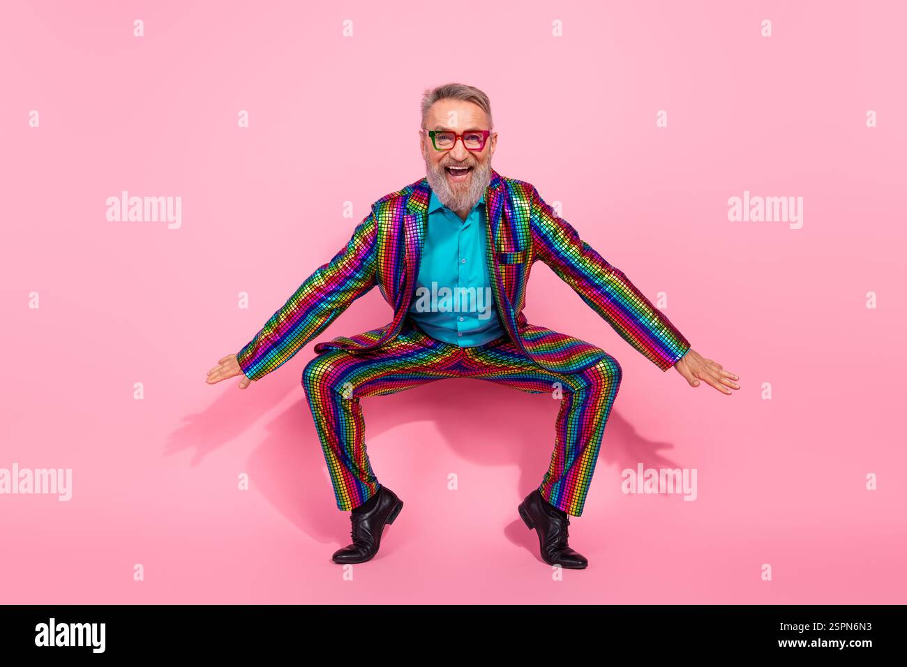 Eccentric senior man in colorful striped suit on pink background, having fun and dancing Stock ...