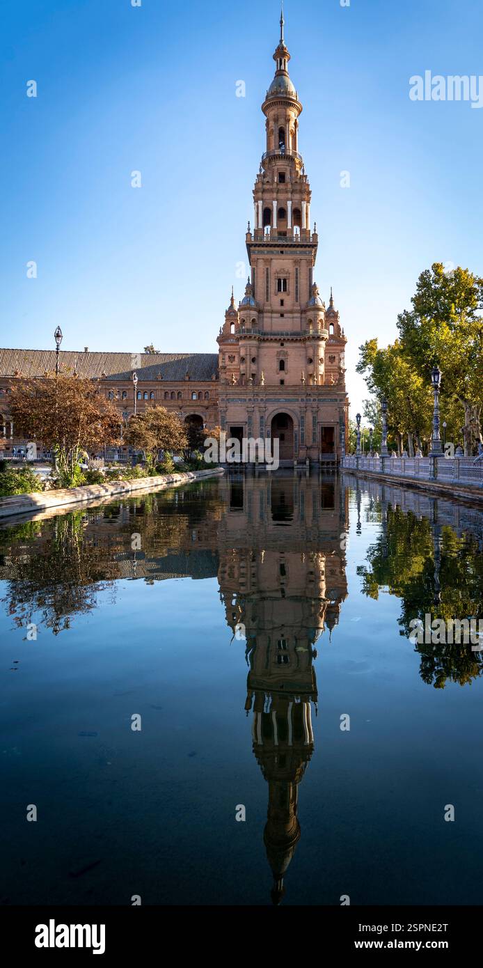 A tall, ornate tower reflected in a calm body of water, surrounded by ...