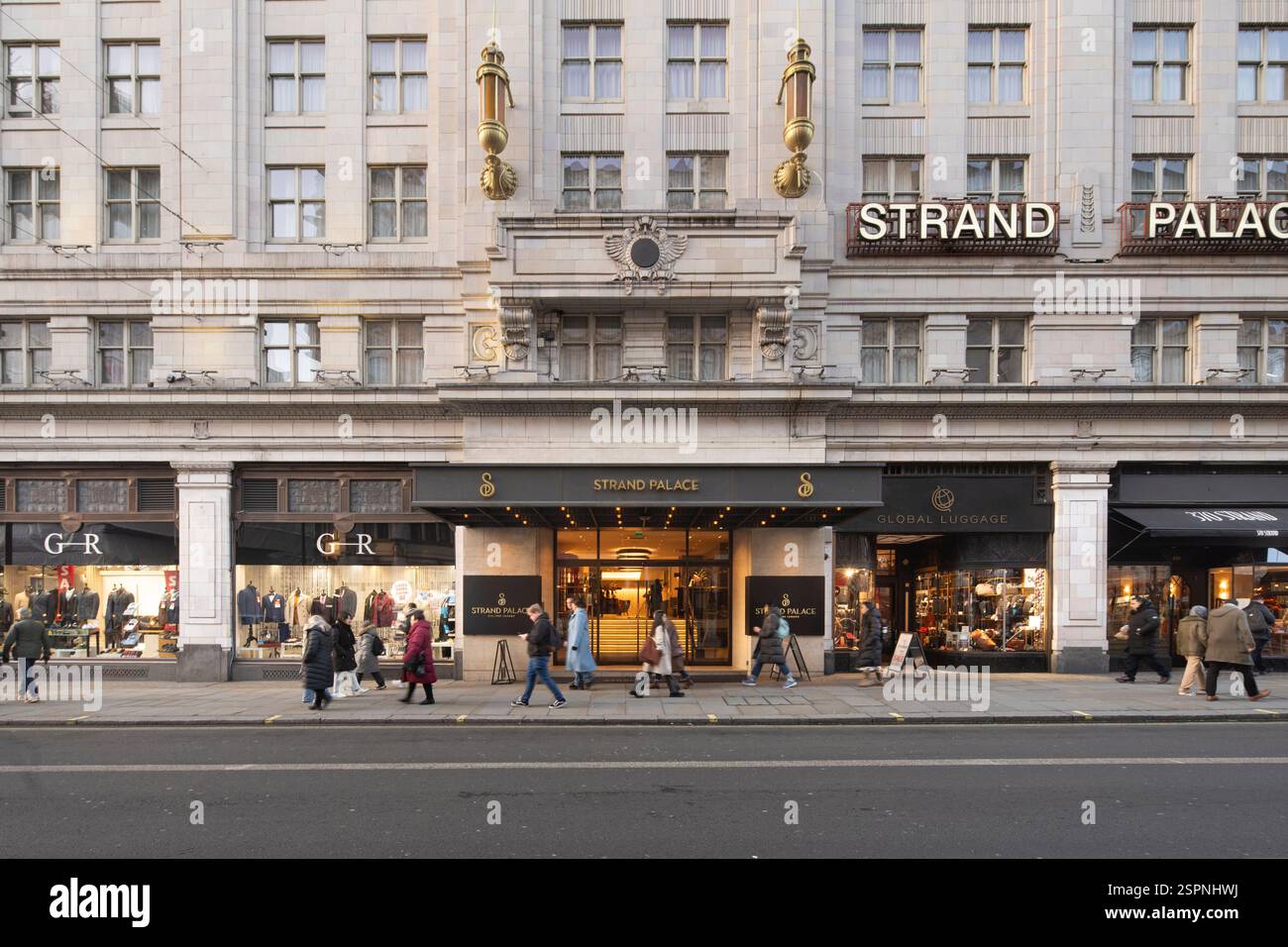 Pedestrians walk along Strand, London, past the Strand Palace Hotel and ...