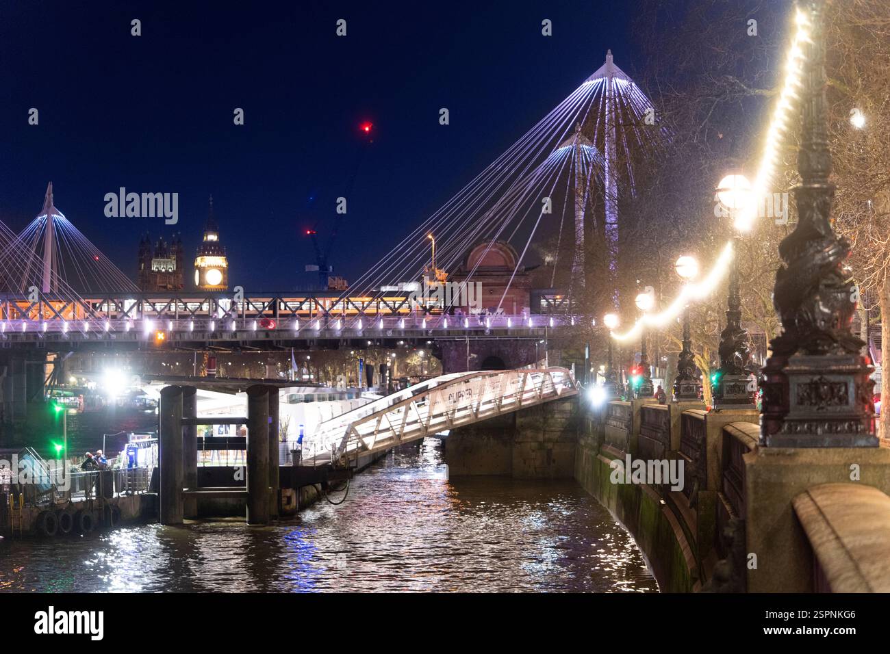 Night view of the Hungerford Bridge over the River Thames in London ...