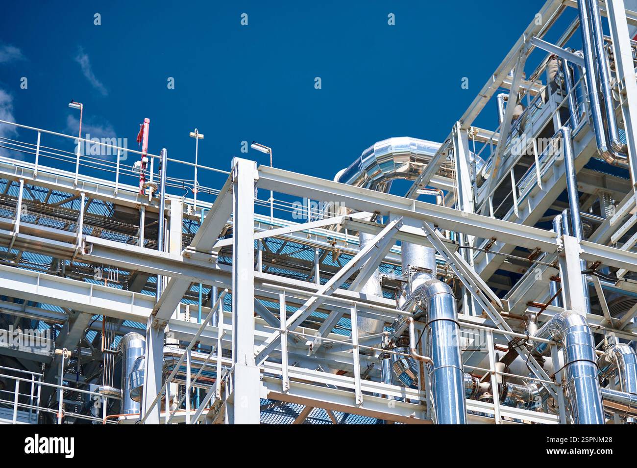 Pipelines and structures of a chemical plant under a clear blue sky at ...